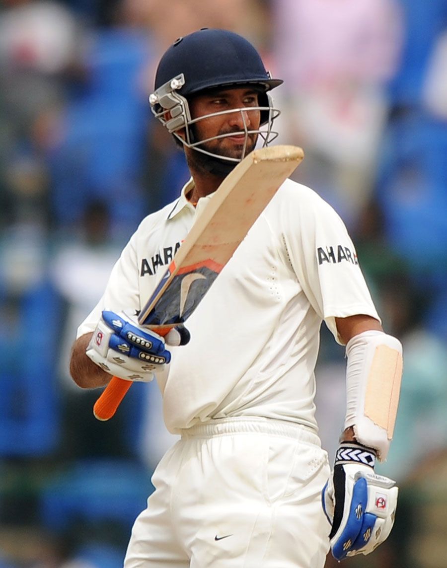 Cheteshwar Pujara raises the bat after reaching his half-century ...