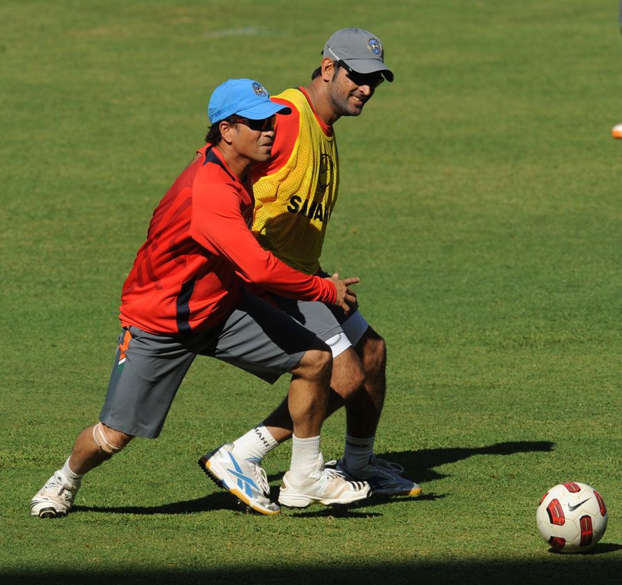Sachin Tendulkar and MS Dhoni jostle for the ball during a warm-up game of football ...