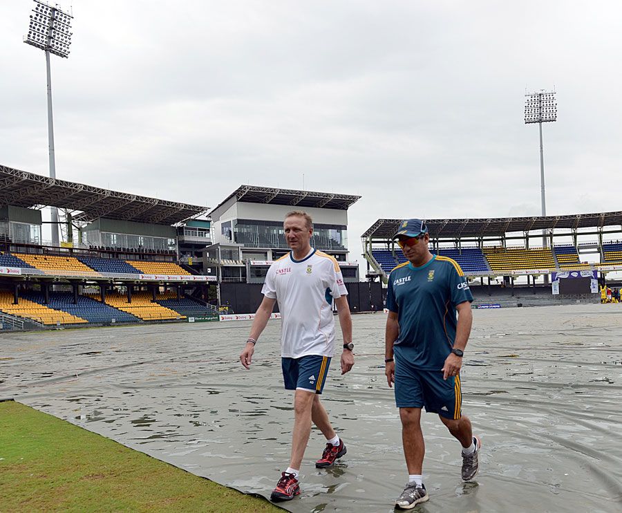 Allan Donald and Russell Domingo walk on the covered outfield ...