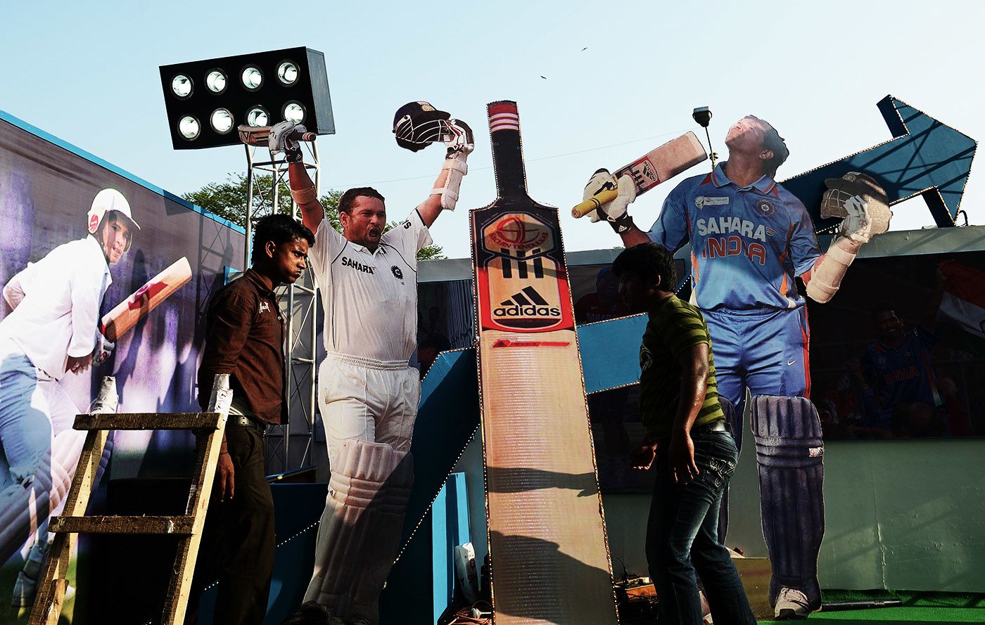 Workers place cut-outs of Sachin Tendulkar on a float in Kolkata ...
