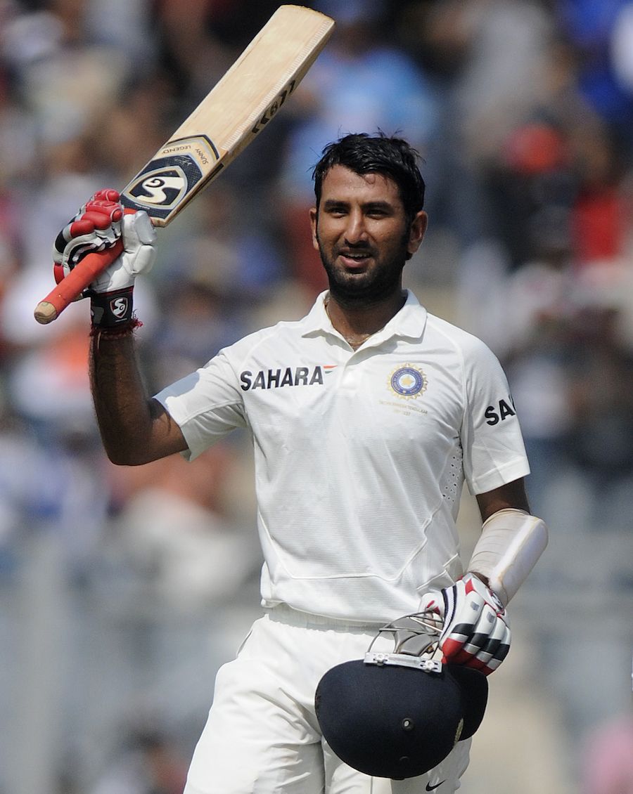 Cheteshwar Pujara raises his bat after reaching his century ...