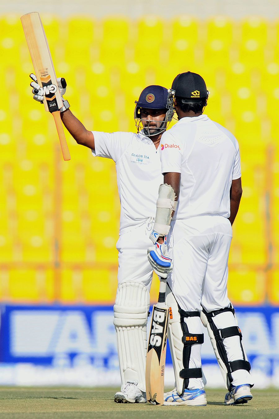 Prasanna Jayawardene raises his bat to the crowd after reaching his ...