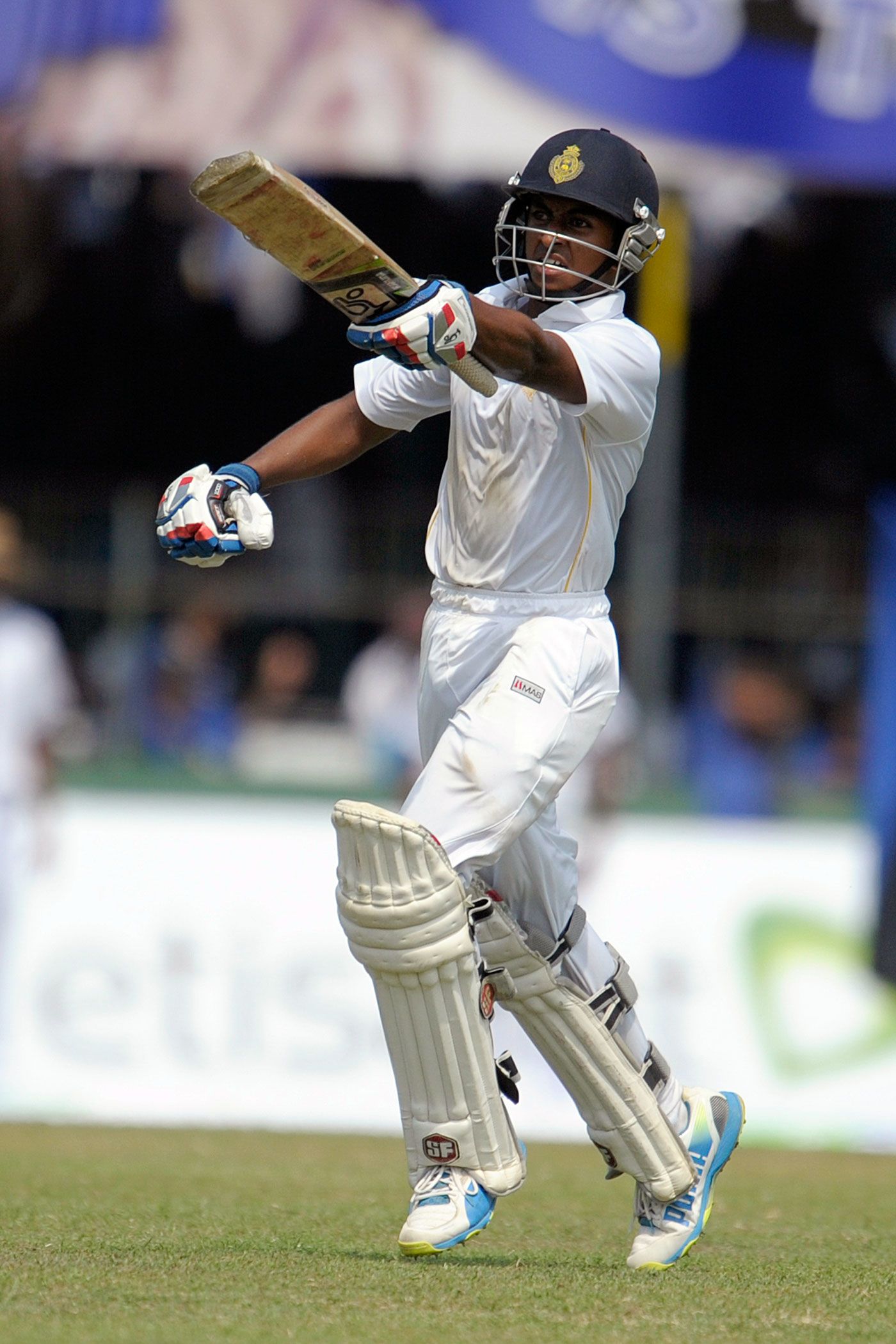 Harith Samarasinghe raises his bat after getting his half-century for ...