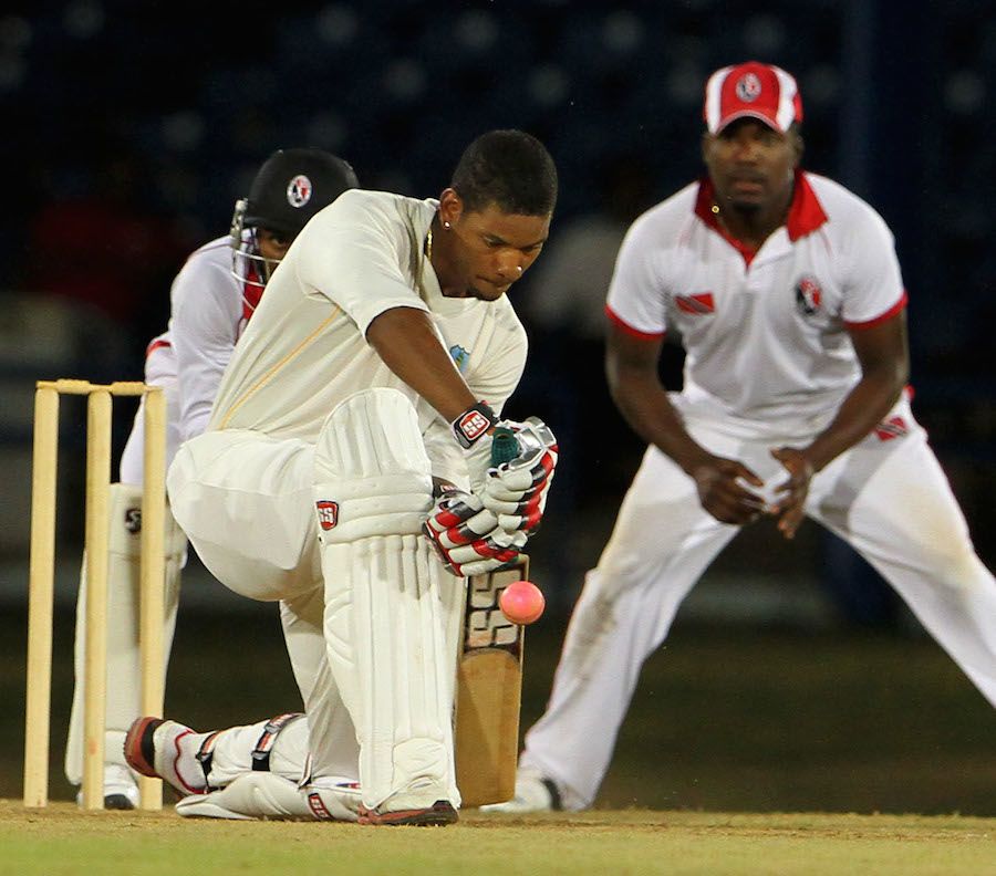 Kieran Powell plays a defensive stroke while Darren Bravo looks on ...
