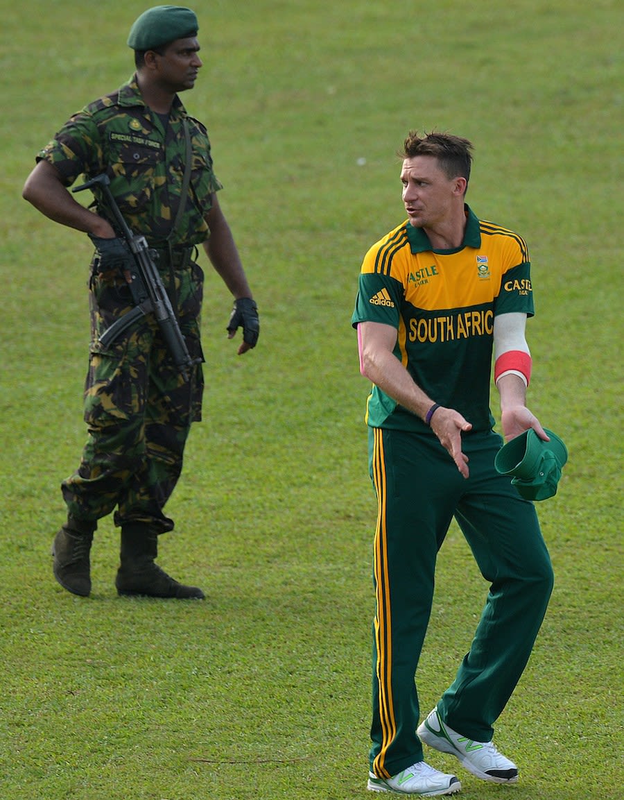 A soldier shadows Dale Steyn as he walks back after the match ...