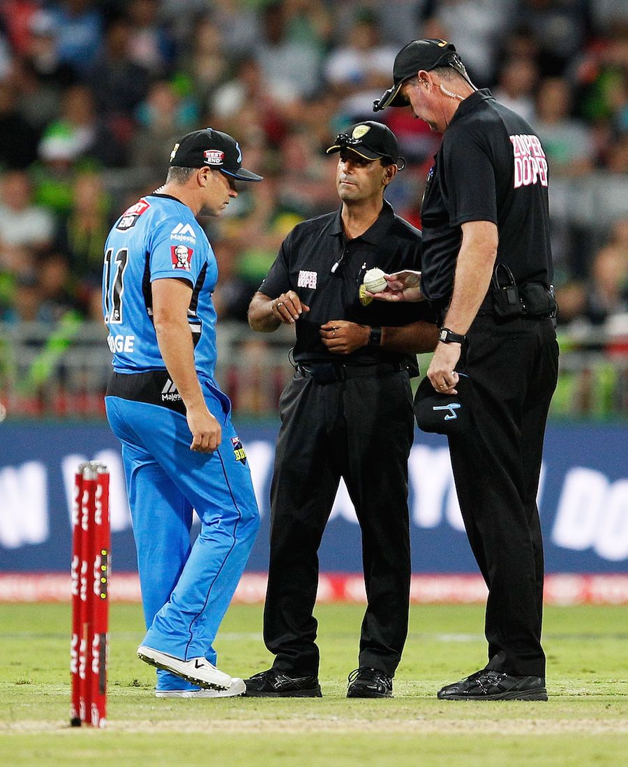 Umpires Greg Davidson and Gerard Abood inspect the ball with Brad Hodge ...