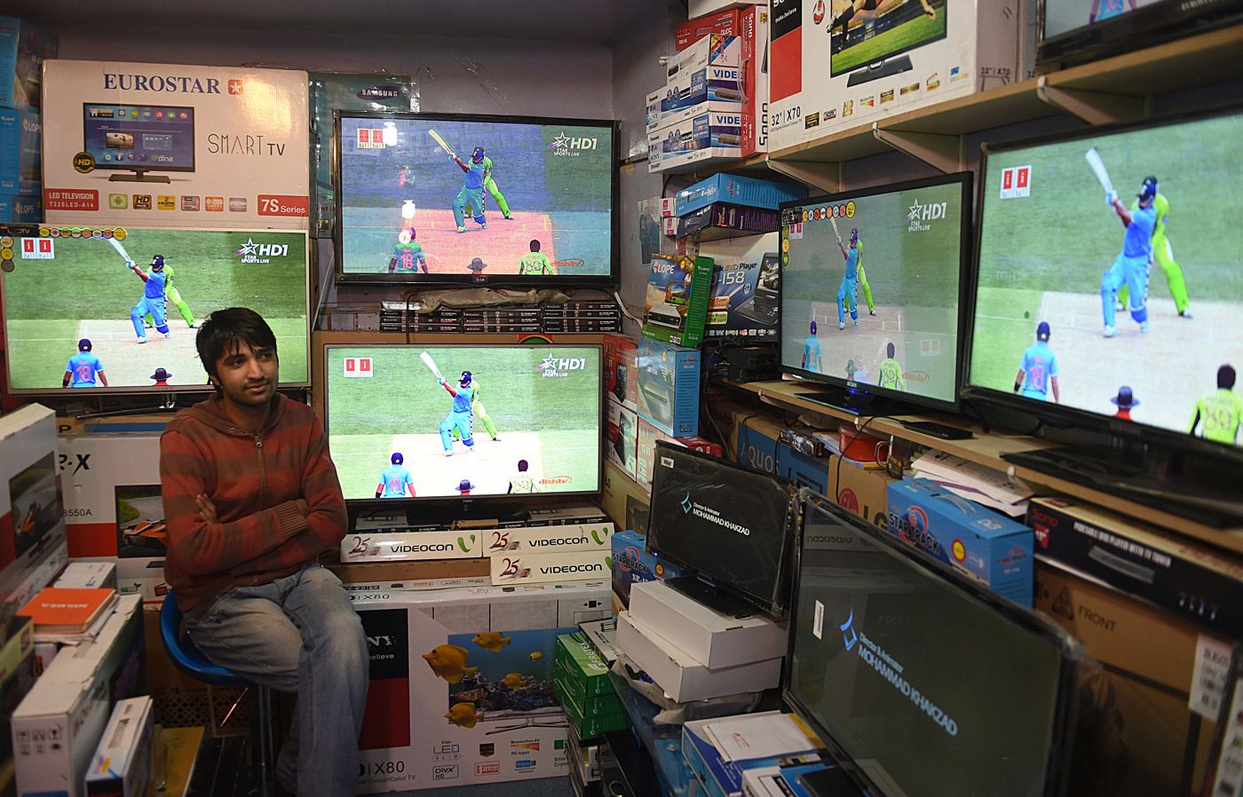 A man watches the India-Pakistan World Cup match in a TV store in Kabul ...