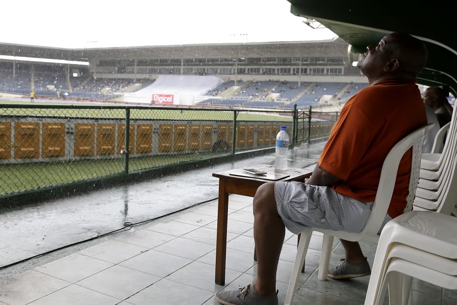 A fan watches the rain fall at Sabina Park | ESPNcricinfo.com