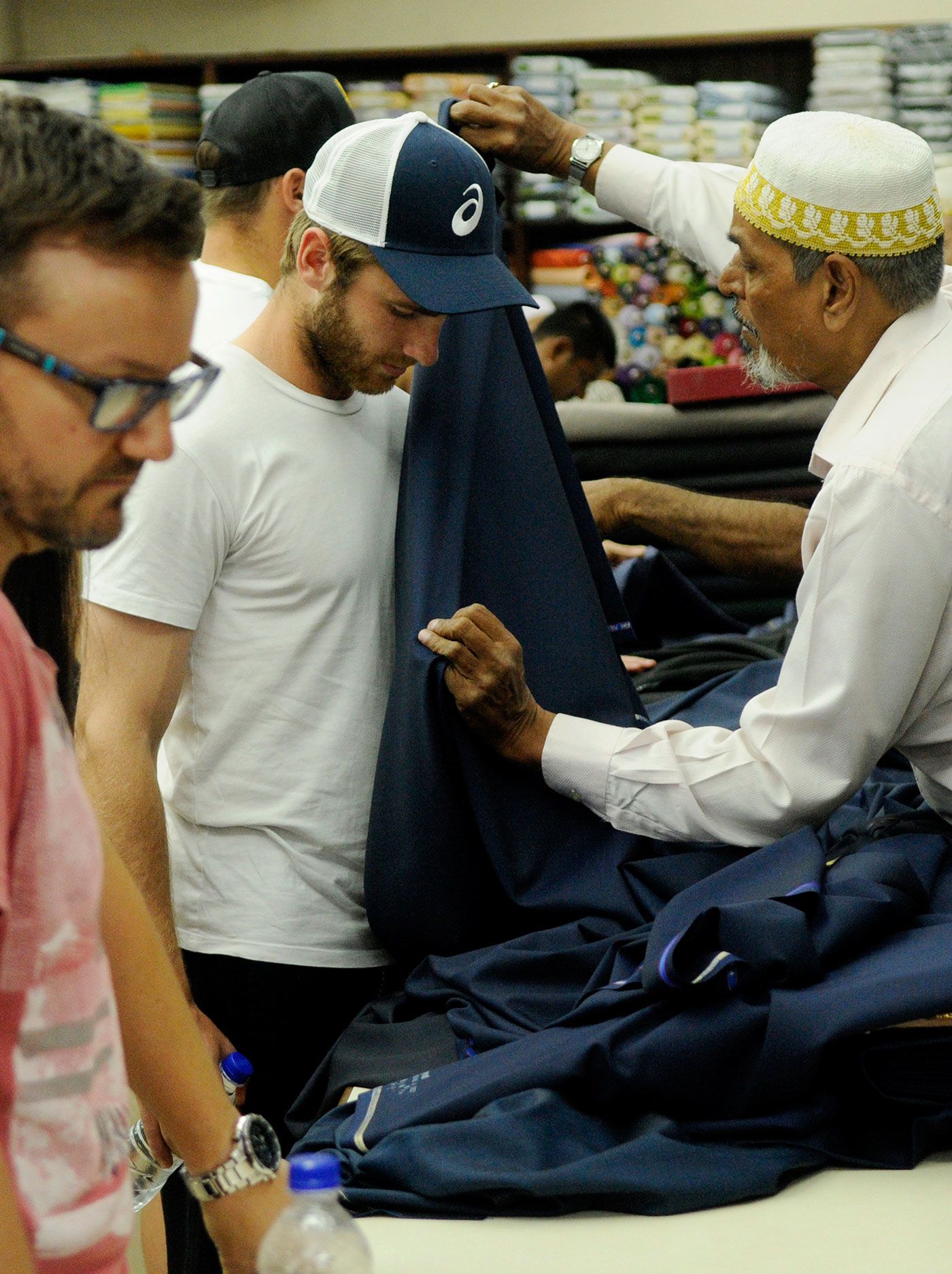 Kane Williamson looks at material for a suit in a men's tailoring ...
