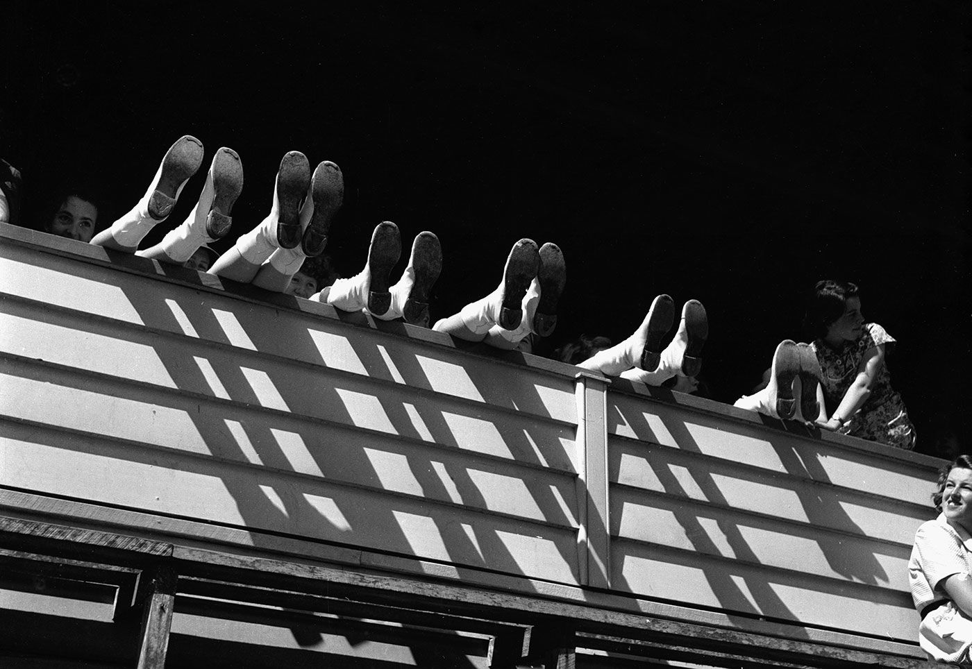 Spectators prop their legs on the railing of a stand | ESPNcricinfo.com