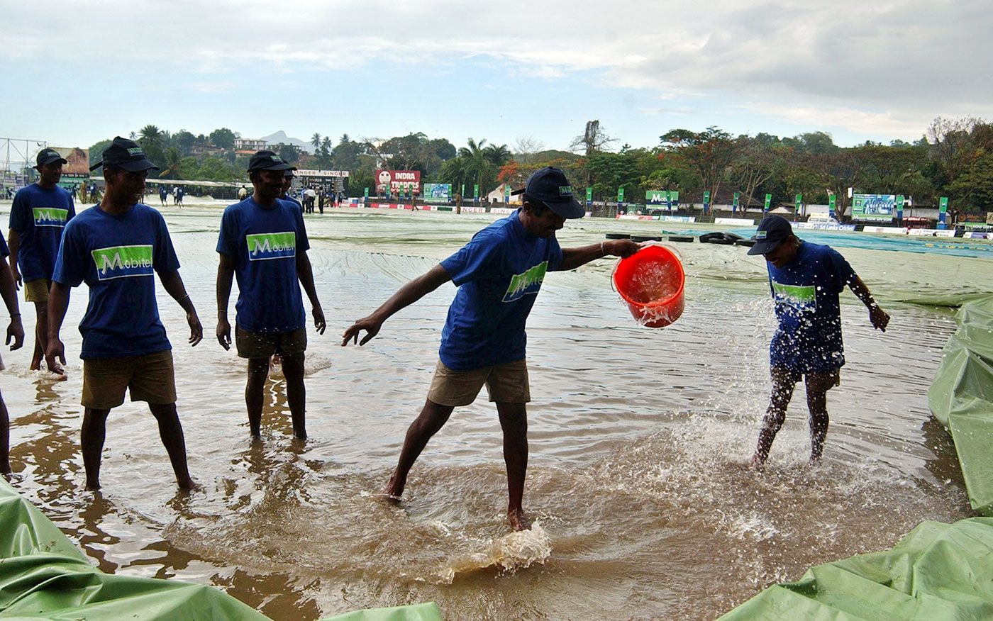 Ground staff use buckets to bail out the water | ESPNcricinfo.com