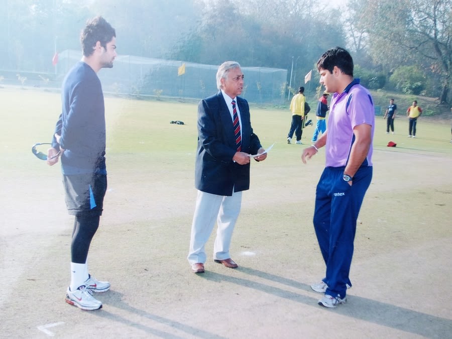 Virat Kohli looks on as Rajinder Goel shares a moment with a young ...