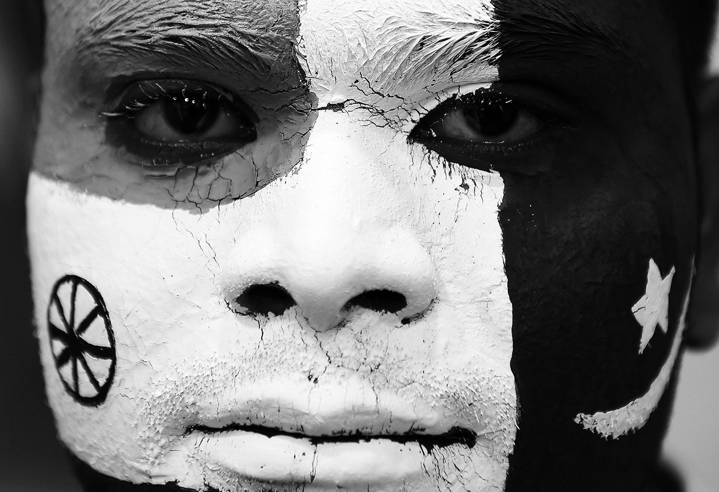 A fan gets his face painted in the India and Pakistan colours ...