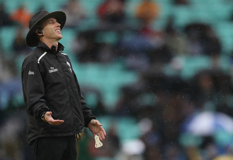 Umpire Chris Gaffaney smiles as rain comes down 24 balls before a ...