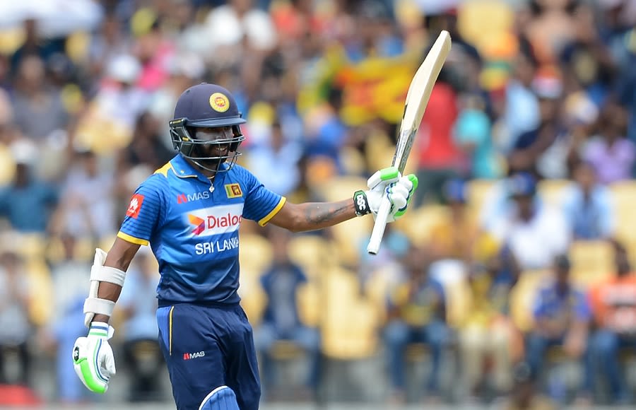 Niroshan Dickwella raises his bat after reaching his third fifty-plus ...