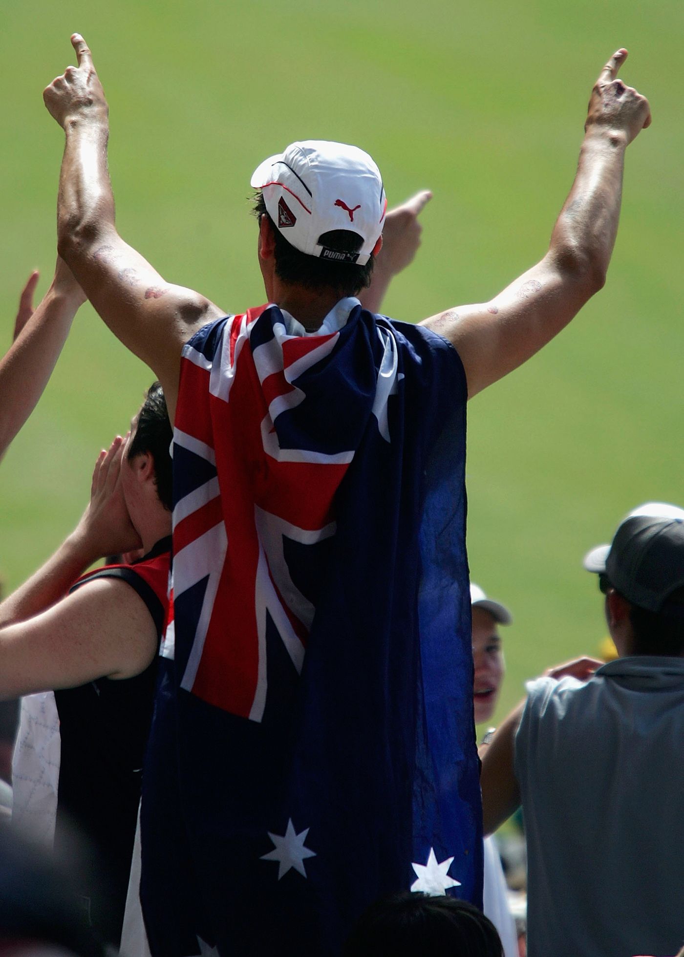 A fan wears the Australian flag like a cape around his shoulders ...