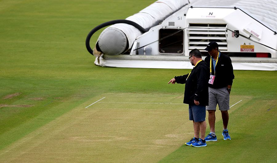 Umpire S Ravi and match referee David Boon have a look at the pitch ...