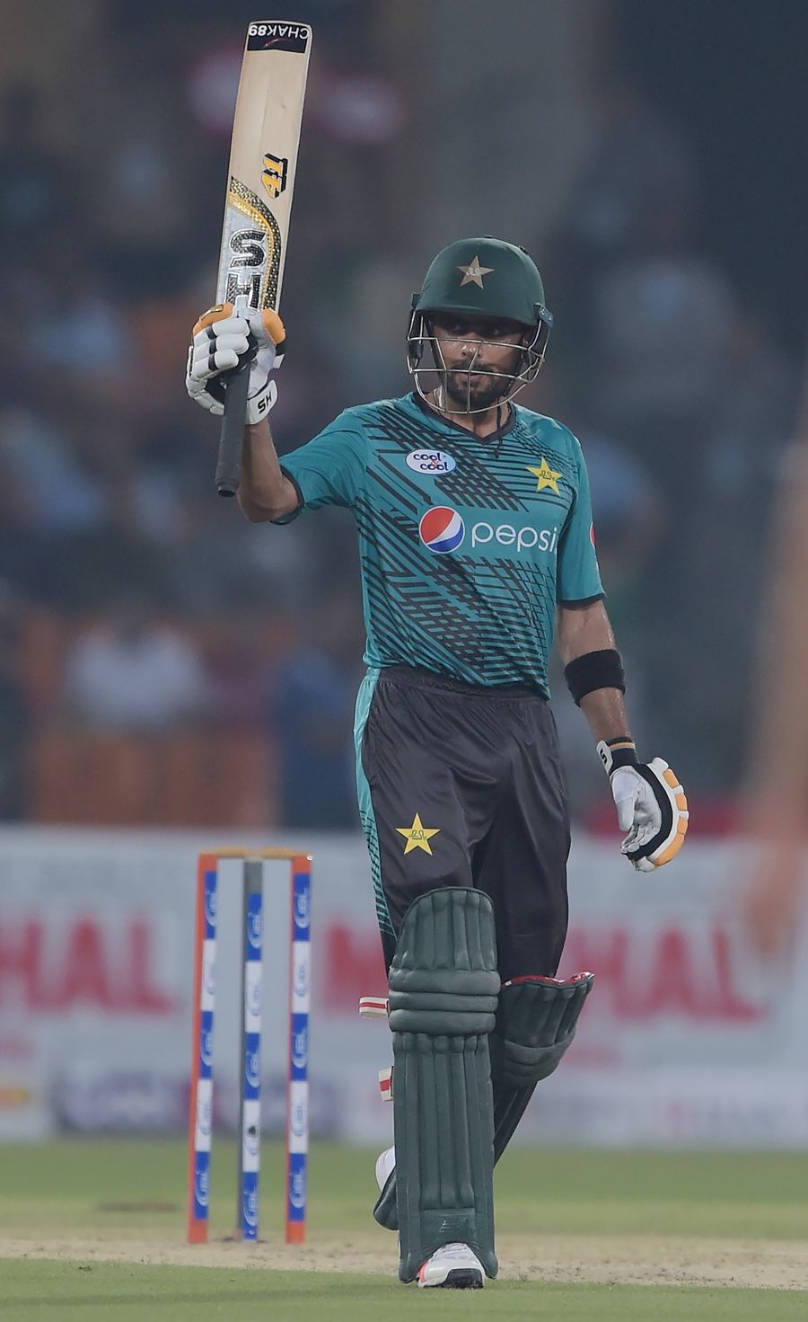 Babar Azam raises his bat after getting to his half century ...