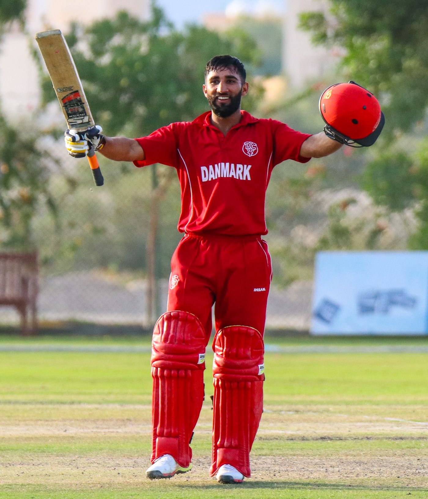 Captain Hamid Shah raises his bat after reaching a century ...