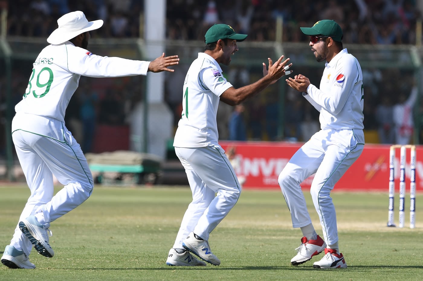 Asad Shafiq and Babar Azam celebrate the fall of a wicket in the slips ...