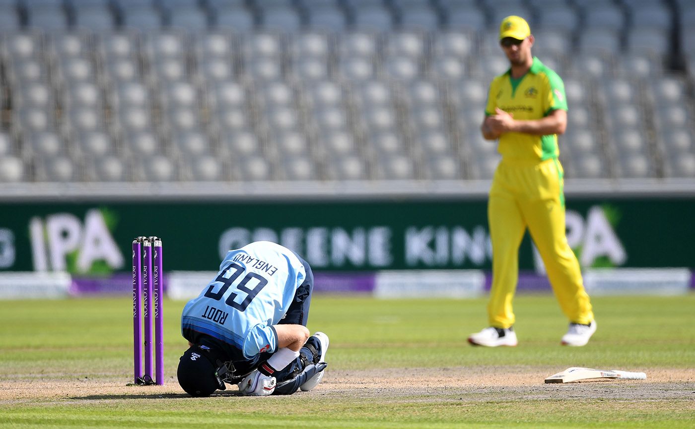 Joe Root reacts after being struck on the knee by the ball ...