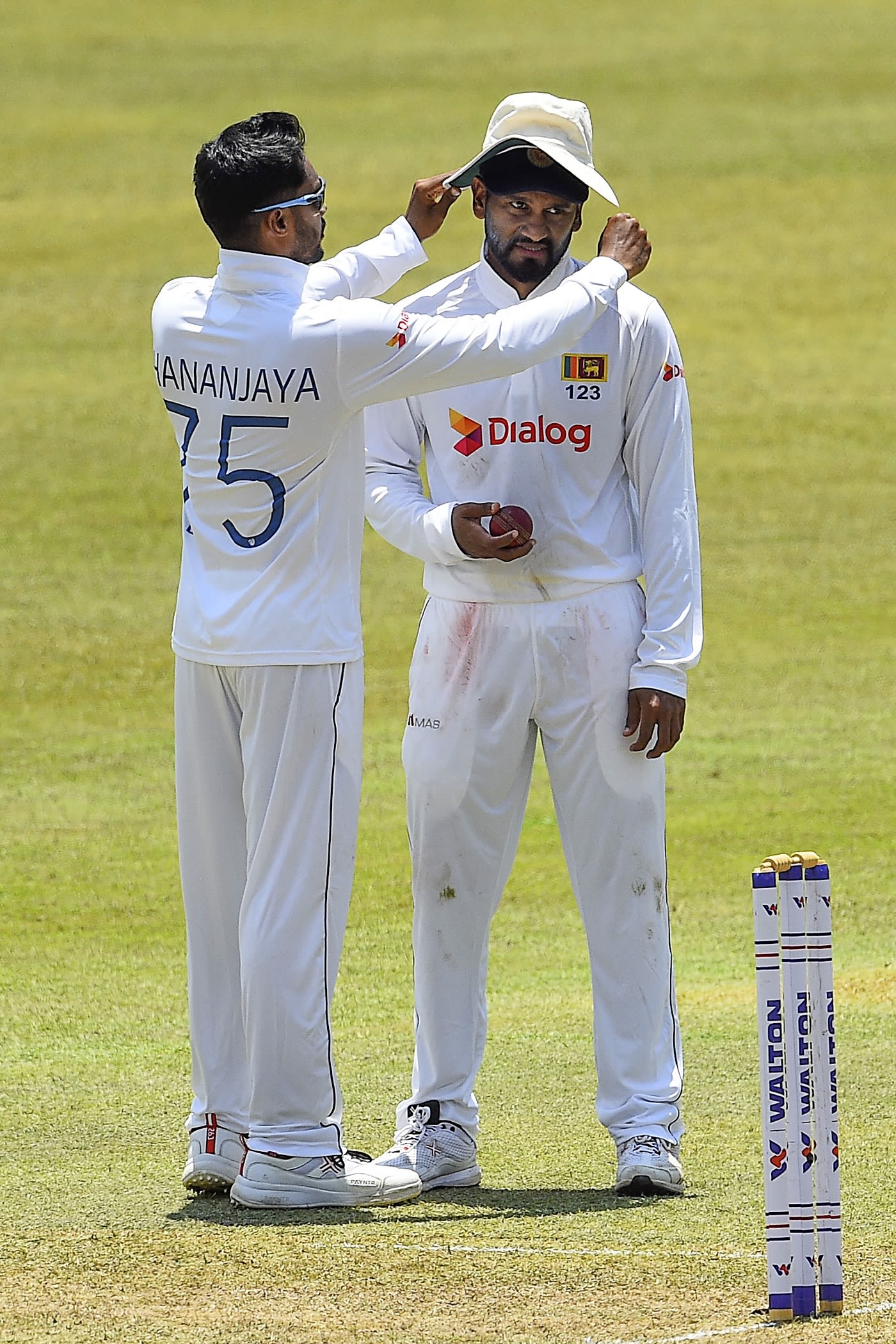 Dhananjaya de Silva puts a floppy hat on Dimuth Karunaratne's head ... Dhananjaya de Silva puts a floppy hat on Dimuth Karunaratne's head ...
