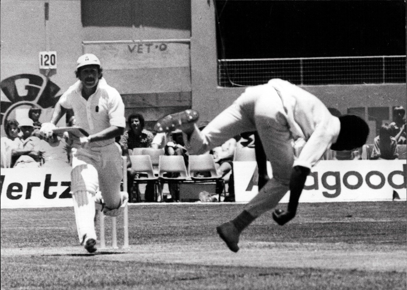 Michael Holding stops a ball from Bruce Laird off his own bowling ...