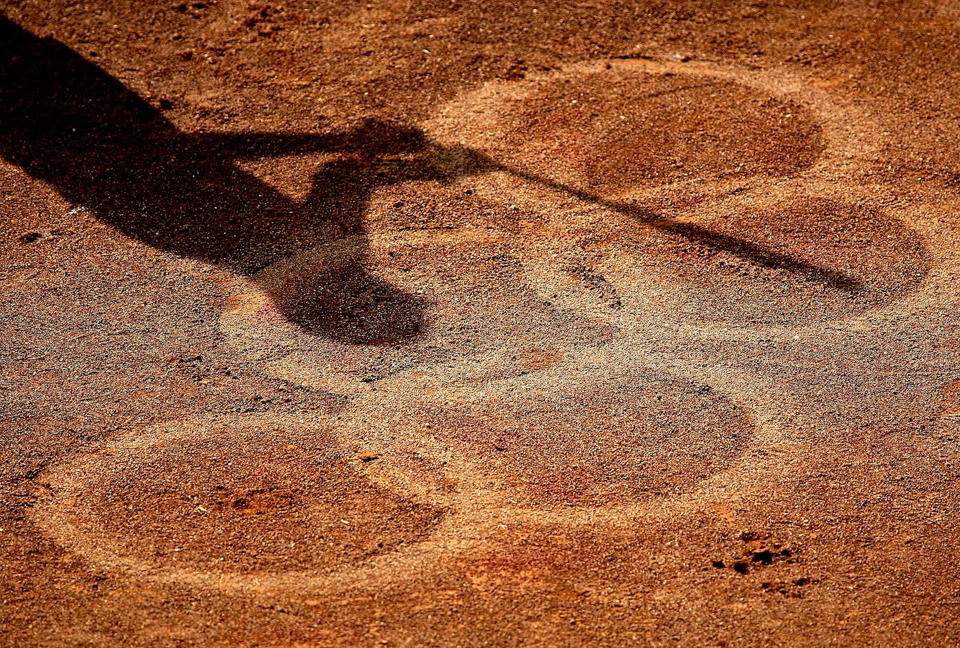 A softball batter's shadow falls across the Olympic rings ...
