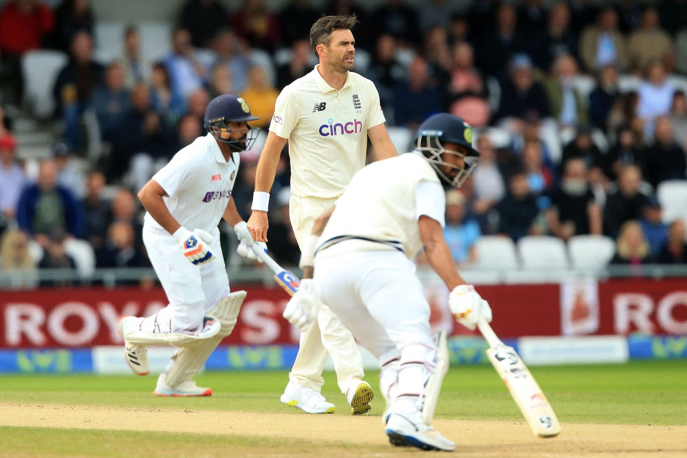 James Anderson looks on as KL Rahul and Rohit Sharma finish a run ...