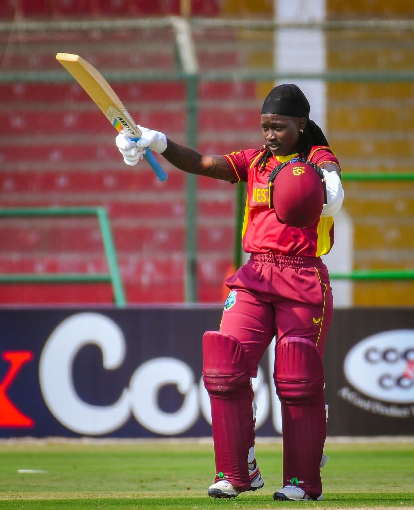 Deandra Dottin raises her bat after getting to her century ...