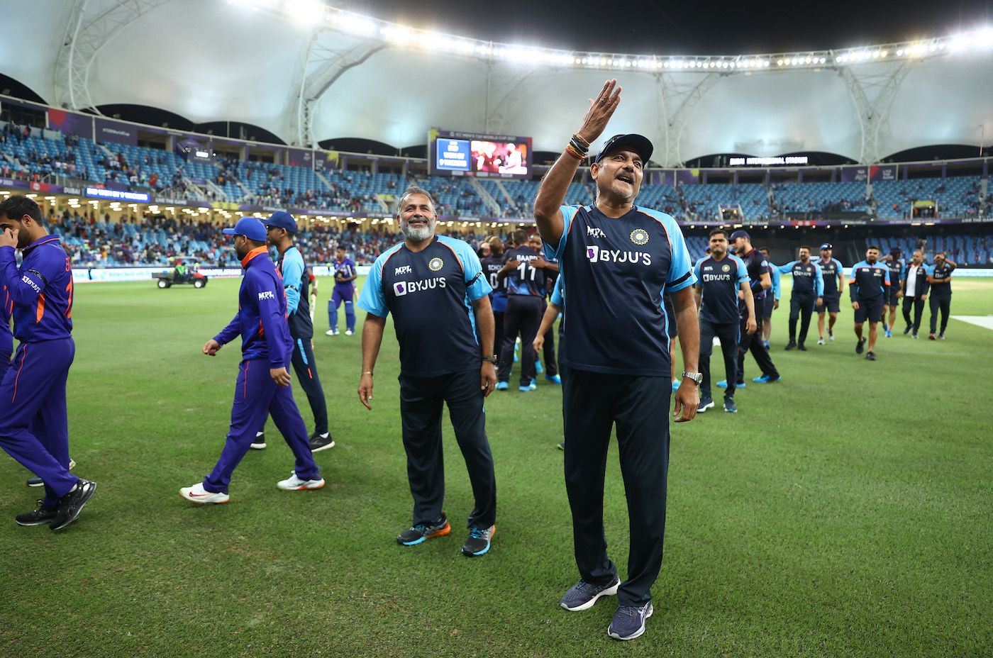 Ravi Shastri gestures to the crowd as Bharat Arun looks on ...