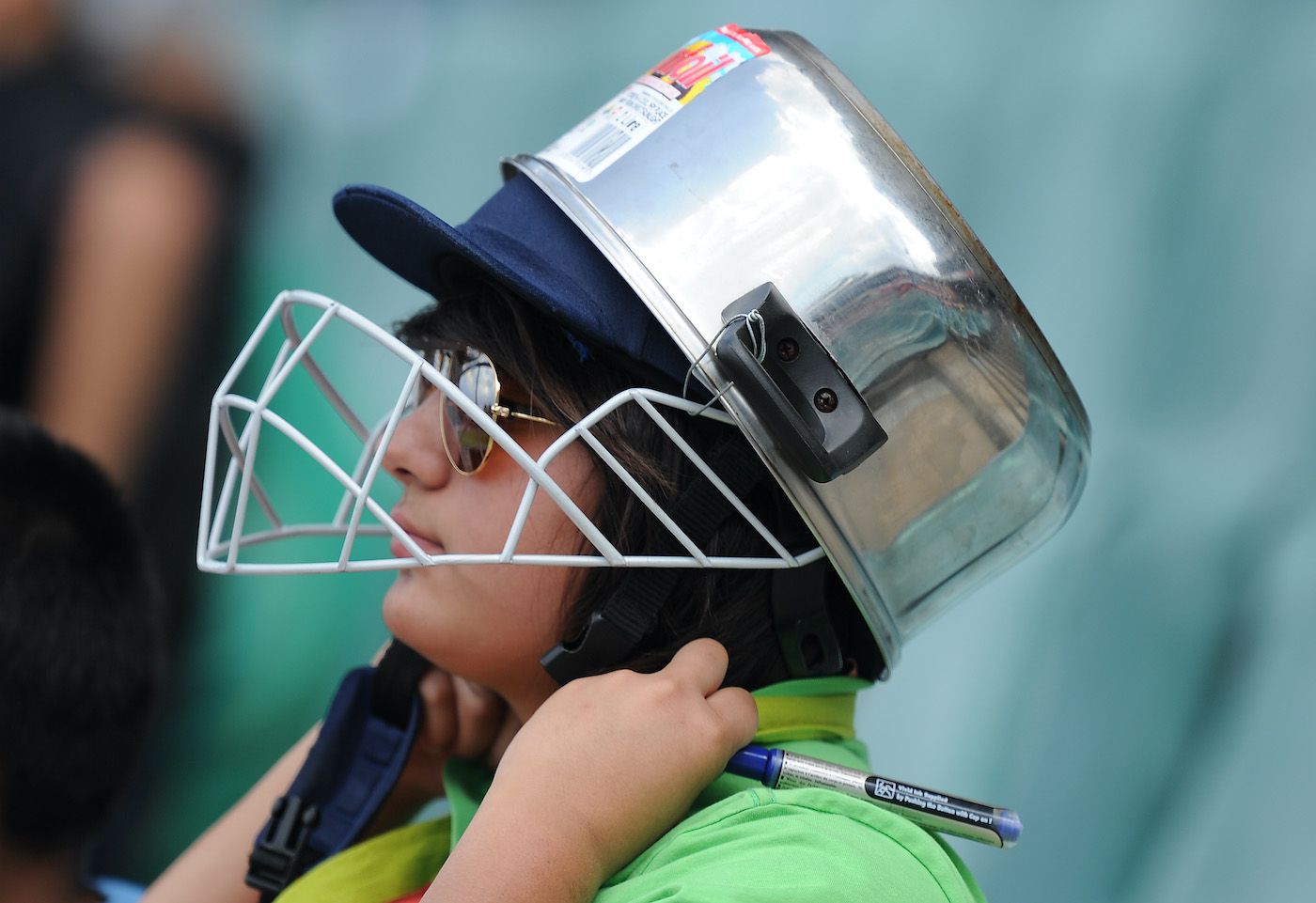 A fan wears a makeshift helmet in the stands | ESPNcricinfo.com