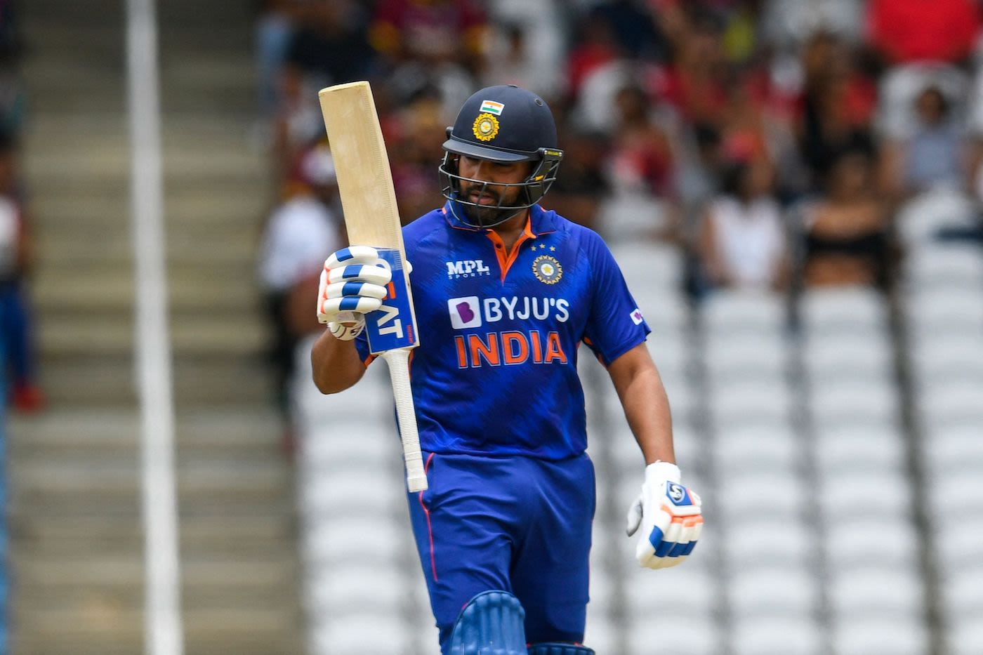 Rohit Sharma raises his bat after getting to a half-century ... Rohit Sharma raises his bat after getting to a half-century ...