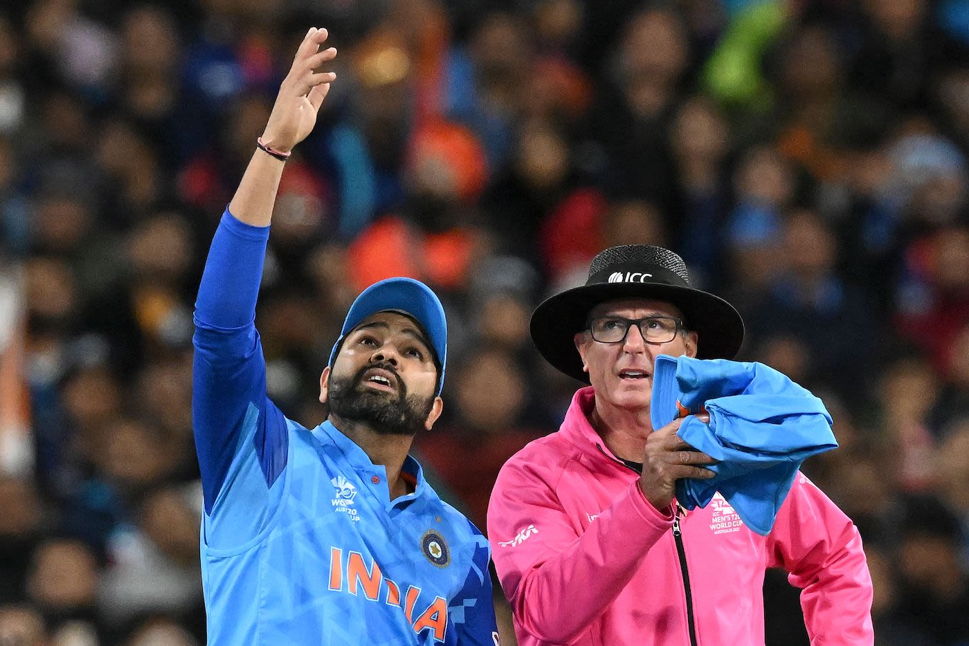 Rohit Sharma talks to umpire Rod Ticker after a lofted shot evaded the fielder because the ball ...