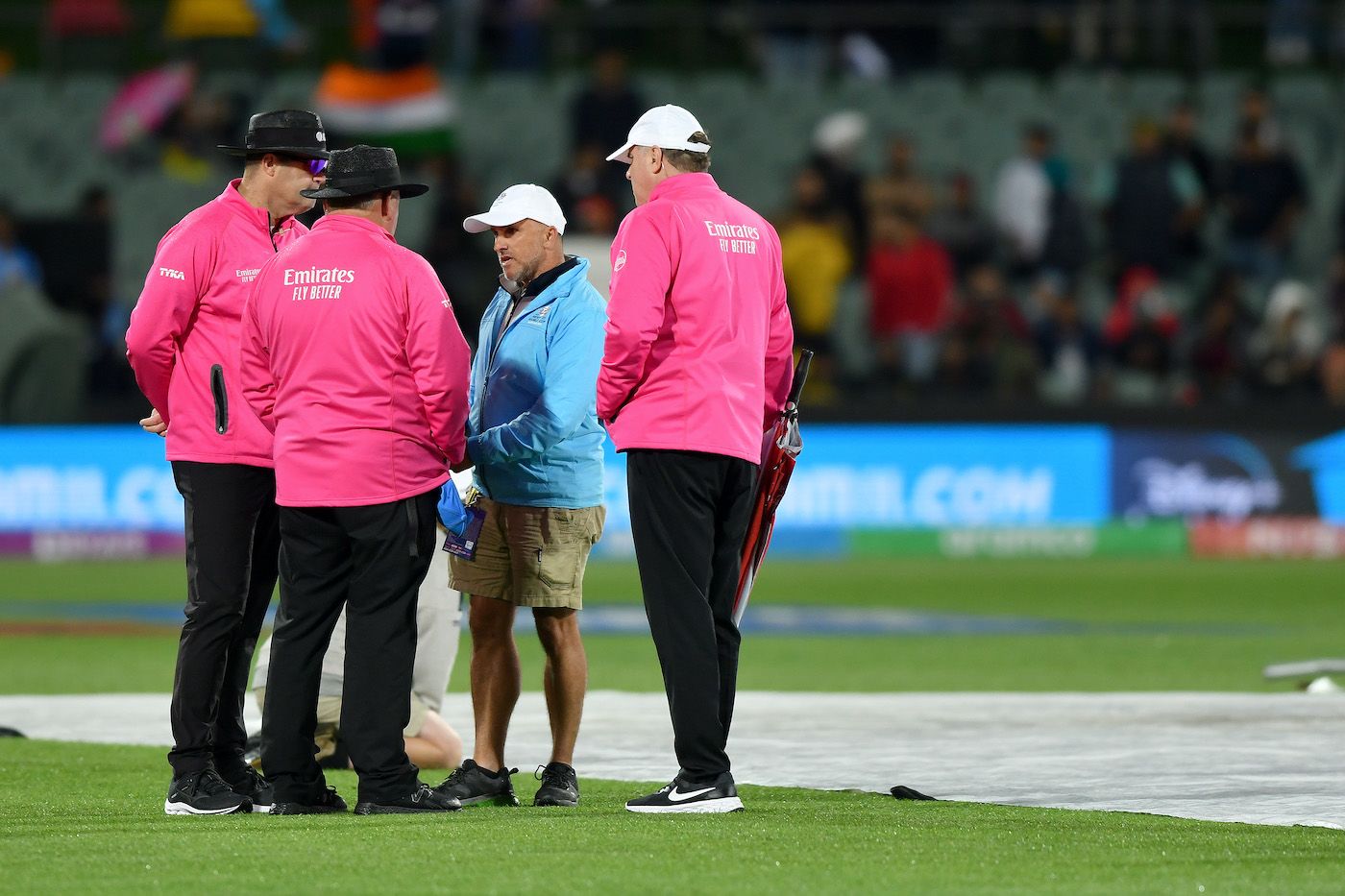 Umpires have a chat with the groundstaff during a rain break ...