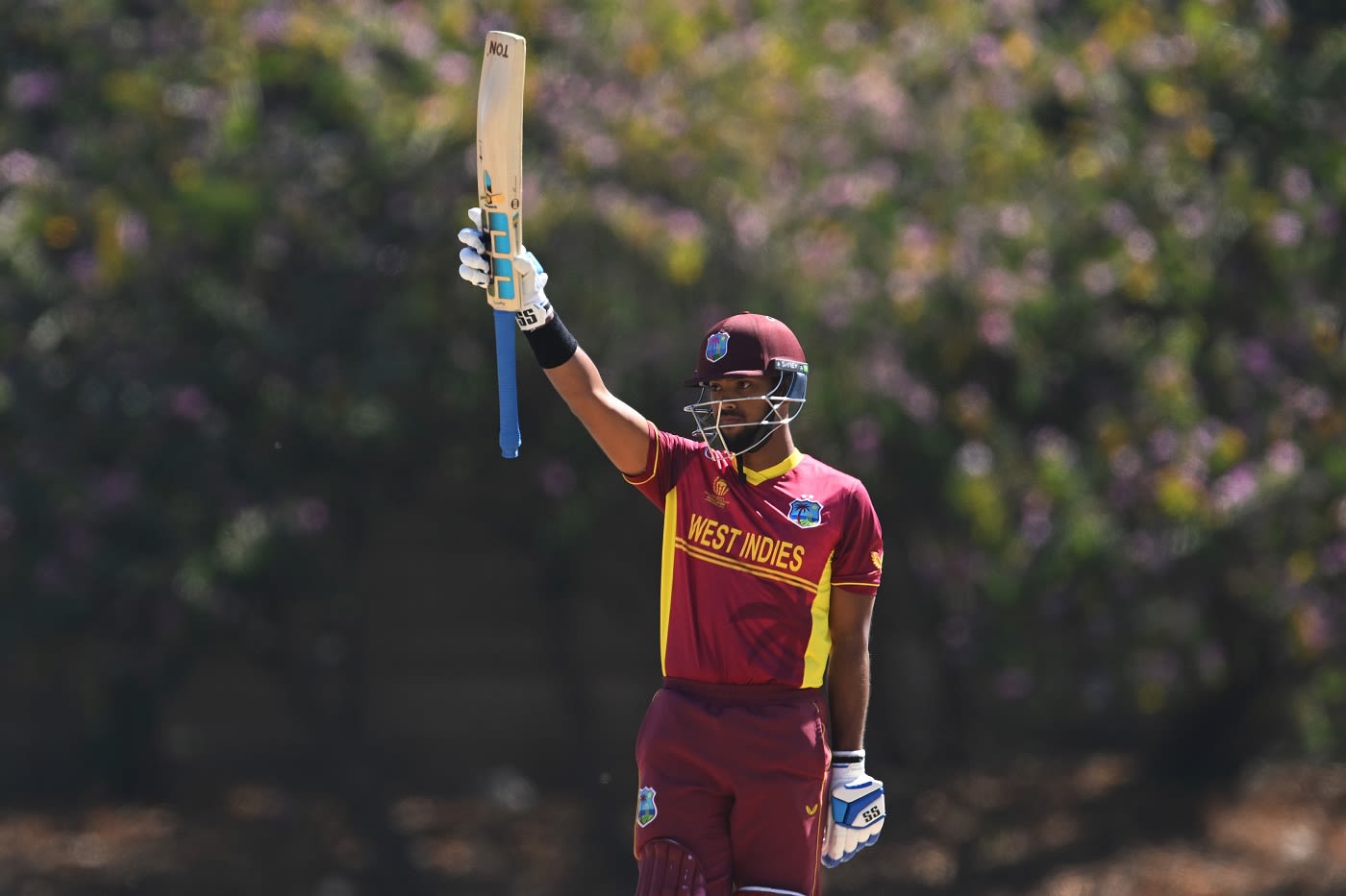 Nicholas Pooran raises his bat after reaching his half-century ...