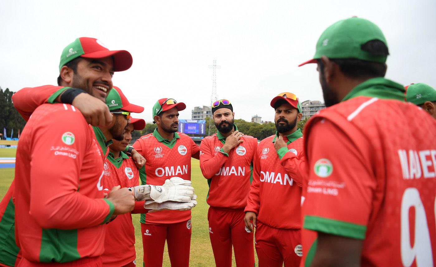 The Oman players get into a huddle before the start of play ...