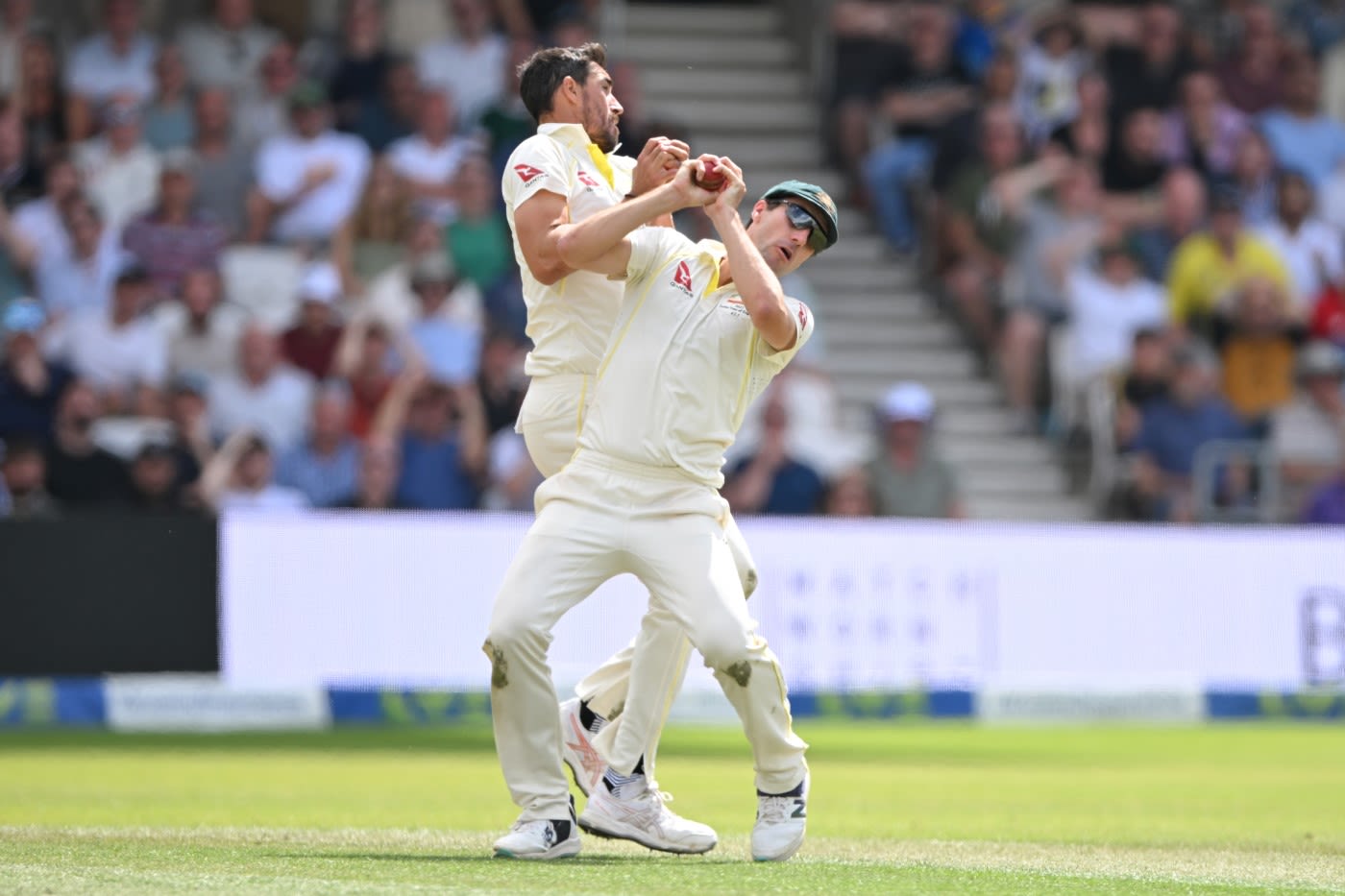 Pat Cummins hangs onto a catch despite colliding with Mitchell Starc ...