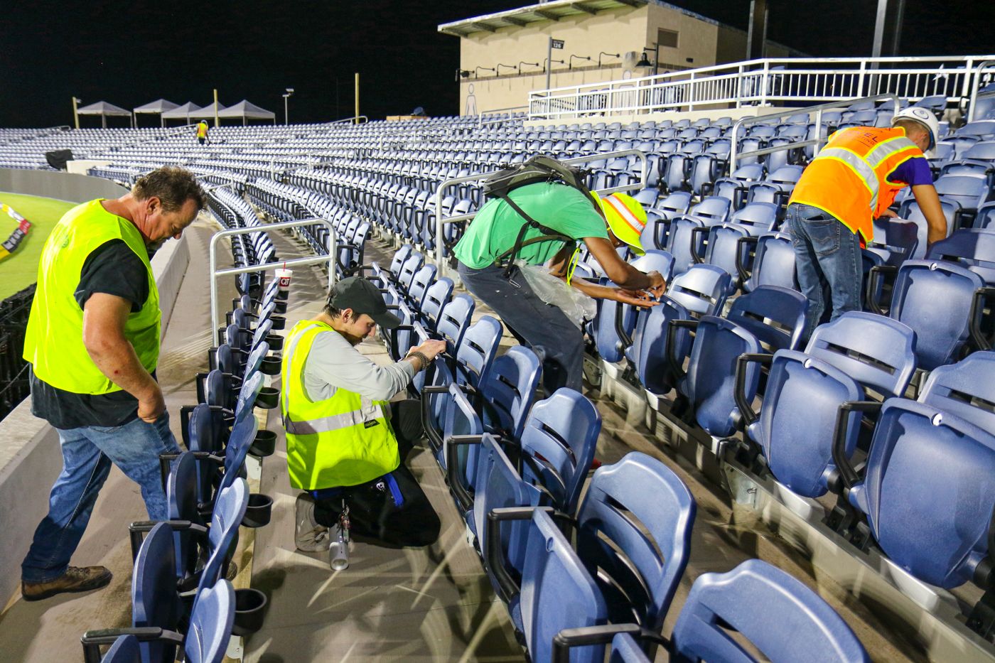 Construction workers finish putting seat number tags onto newly ...