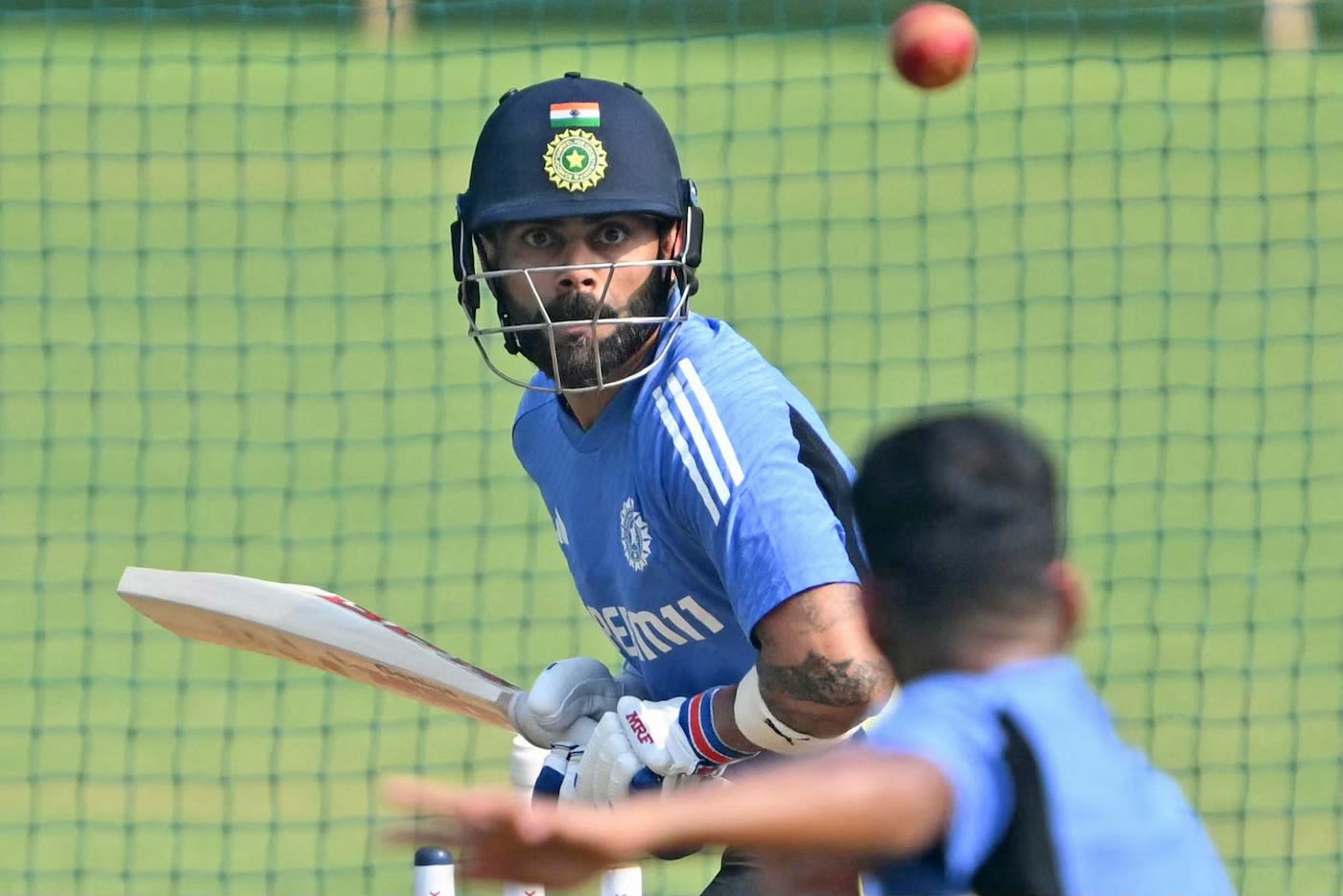 Virat Kohli gives the ball a good stare as he takes throwdowns ...