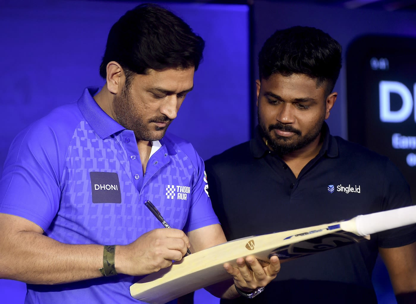 MS Dhoni signs a bat as Sanju Samson looks on | ESPNcricinfo.com