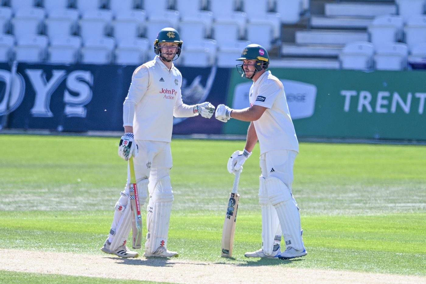 Lyndon James touches gloves with Matt Montgomery during their 118-run ...
