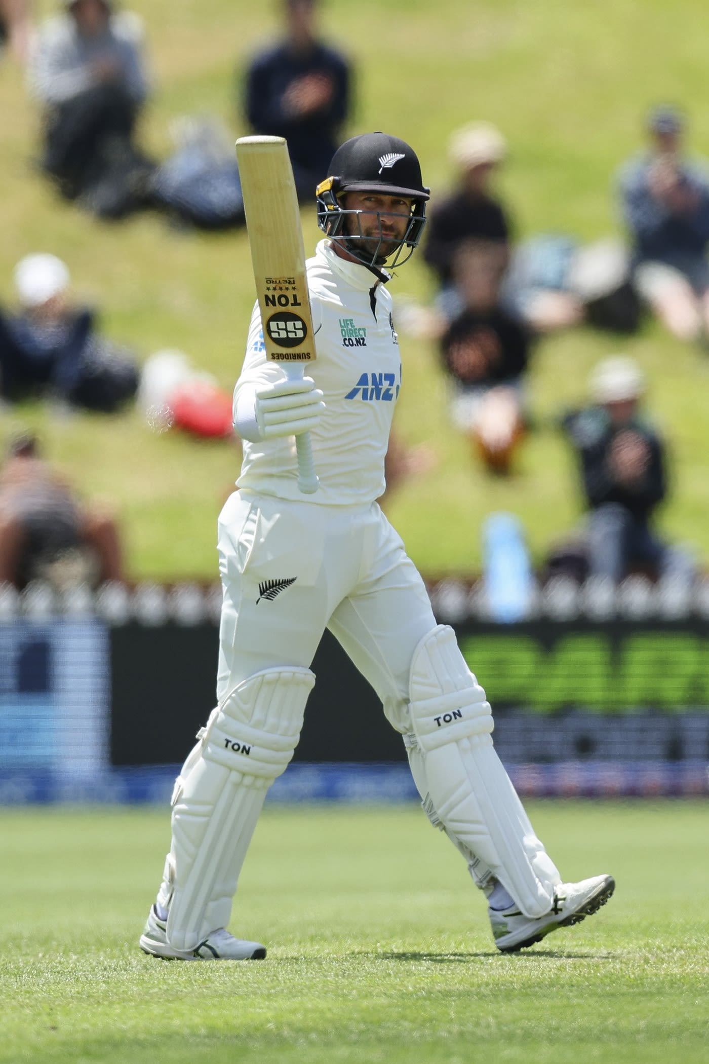 Devon Conway raises his bat after getting to his first half-century ...