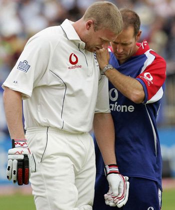 Andrew Flintoff receives treatment on his shoulder from Kirk Russell ...