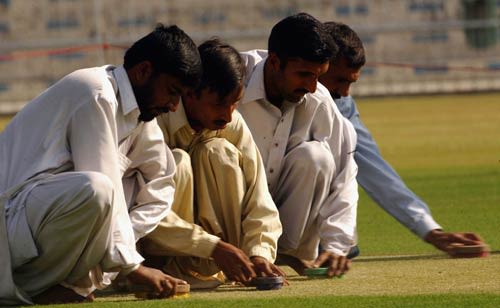 Groundsmen work on the pitch at the Rawalpindi Cricket Stadium ...