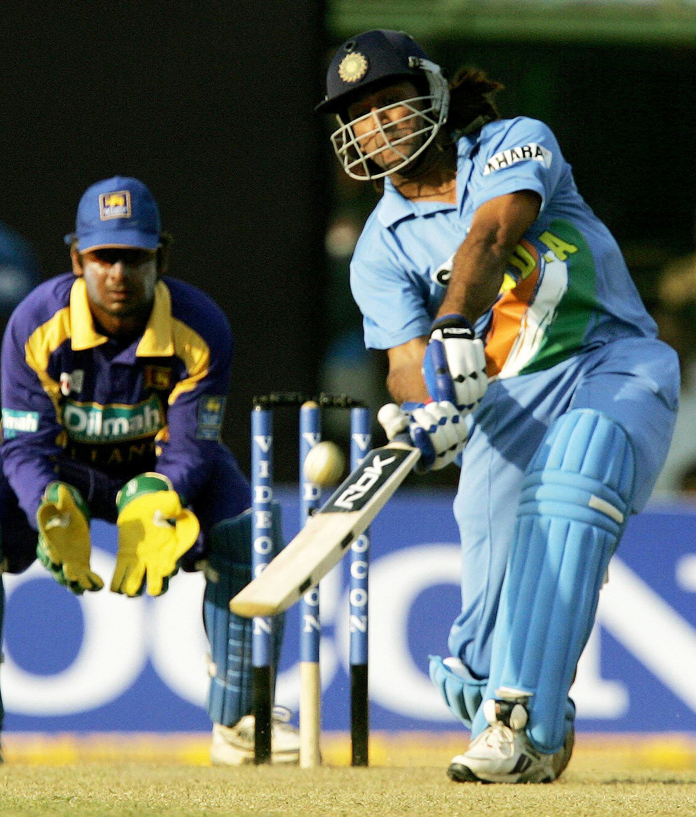 Kumar Sangakkara watches Mahendra Singh Dhoni launch into a six ...