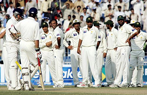 The Pakistan side wait to hear the third umpire's decision ...