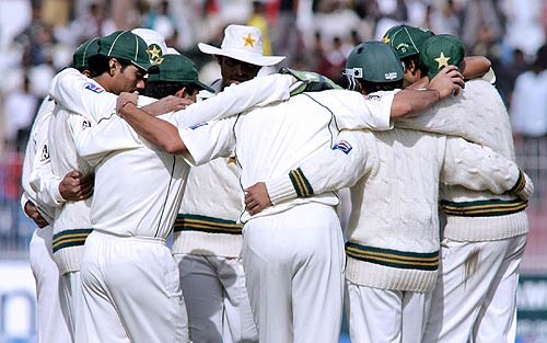 Pakistan players get together for a team huddle after the fall of a ...