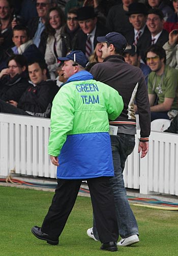 A spectator is escorted to the police after he ventured, briefly, onto ...