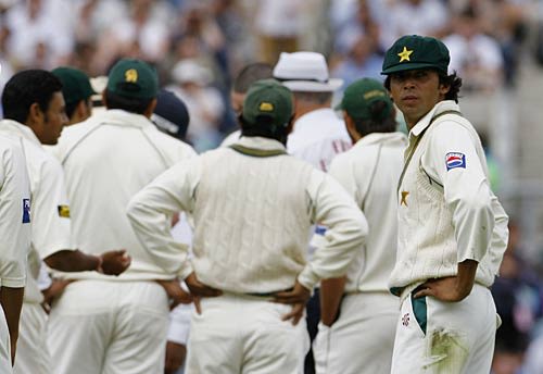 The Pakistan players huddle around the umpires as the ball is changed ...
